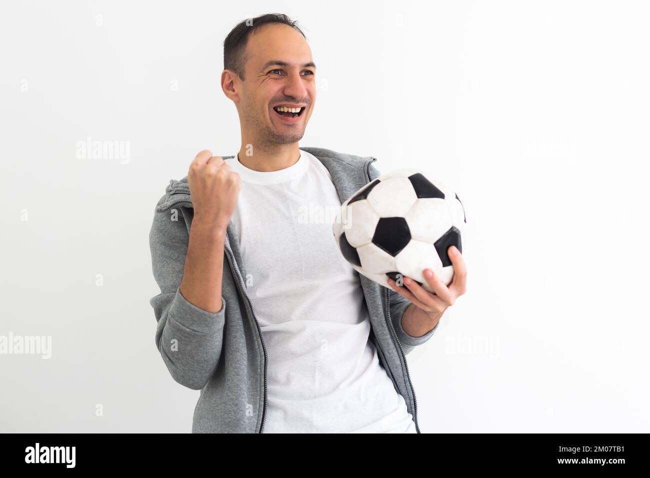 Handsome player man playing soccer holding football ball over ...