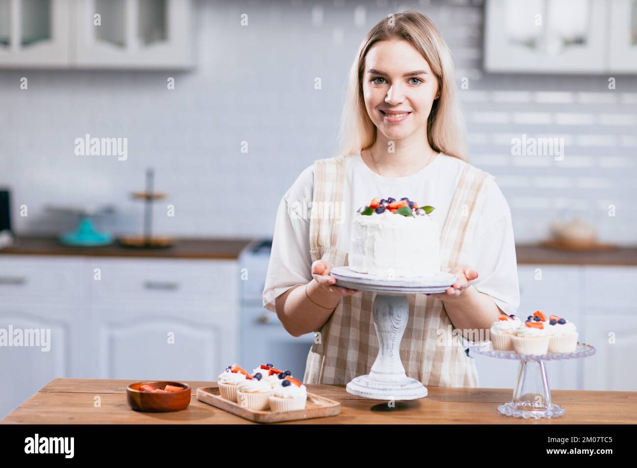 Pastry chef confectioner young caucasian woman hold in hand cake on ...