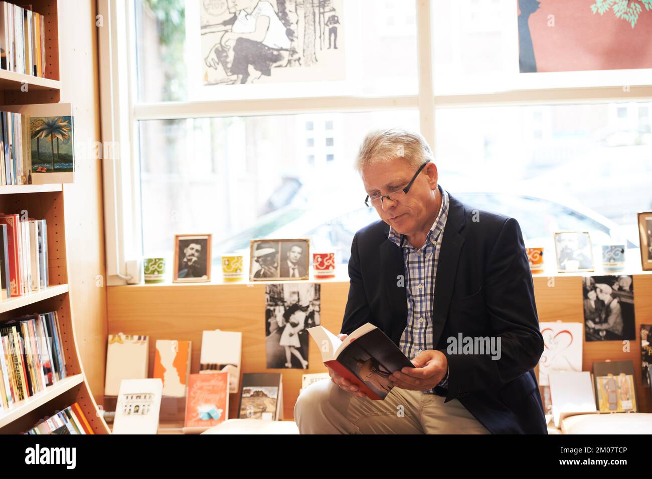 Reading is his favorite hobby. a mature man reading a book in a ...