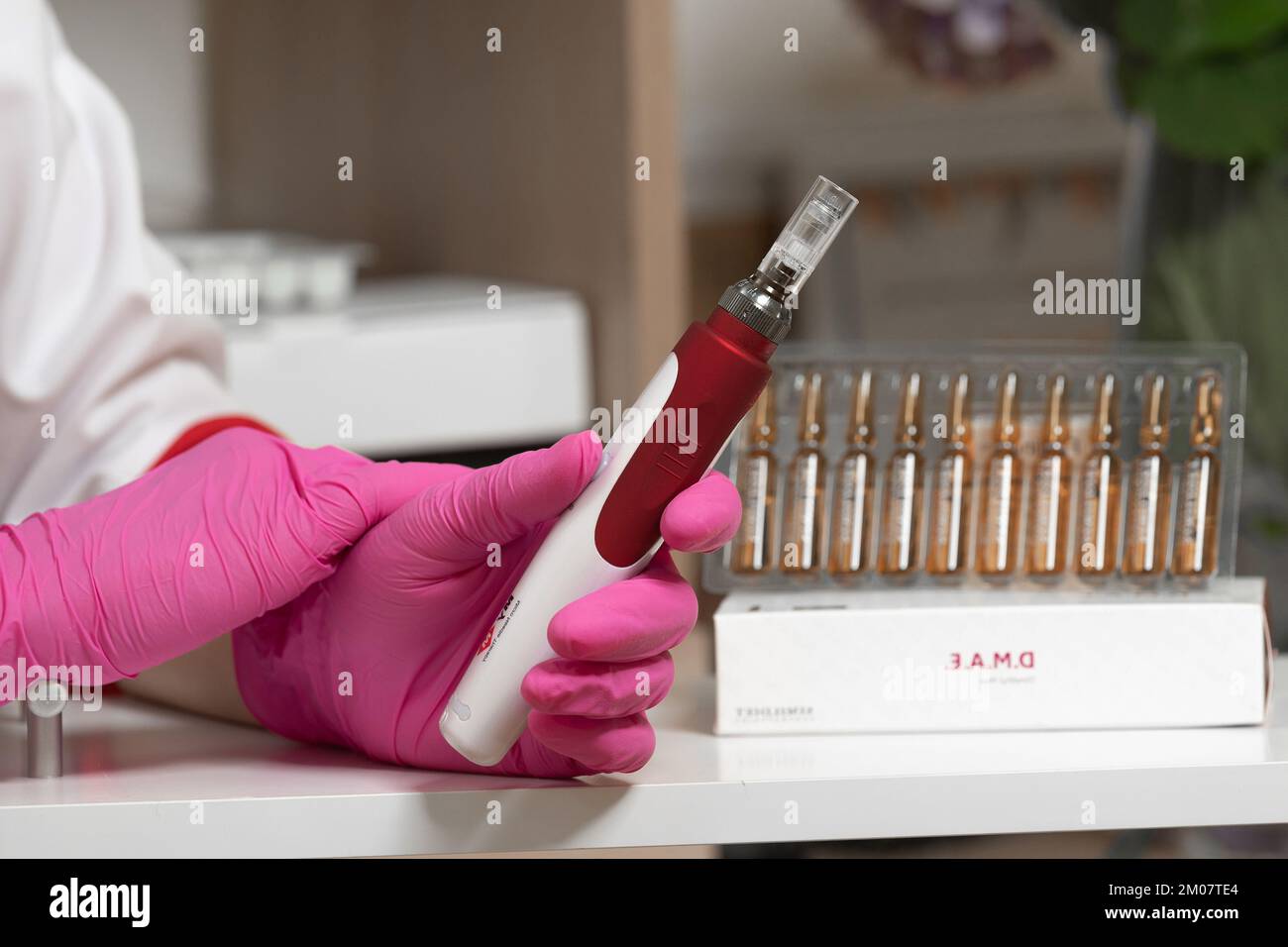 The cosmetologist holds in his hands a dermapen, a tool for mesotherapy ...
