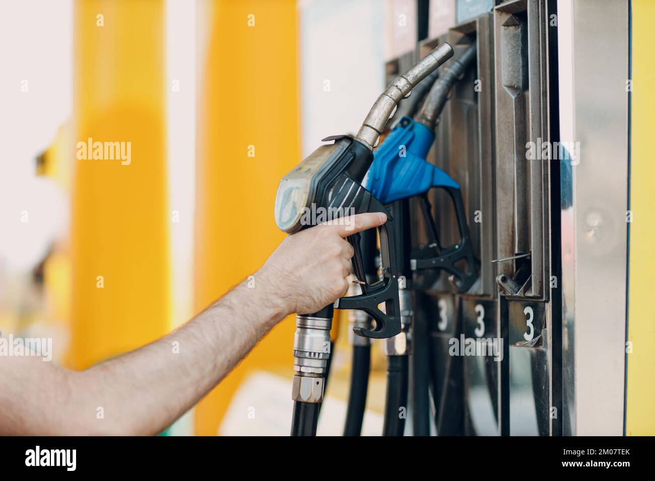 Man holding filling gun in his hand at gas station Stock Photo - Alamy