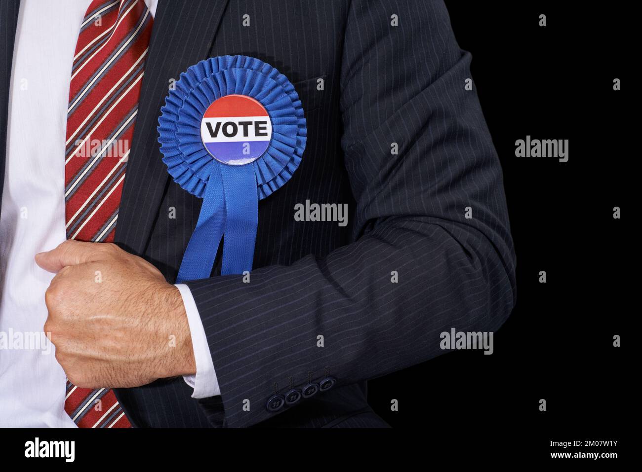 Voting for democracy. Cropped view of a man in a suit wearing a voting ...