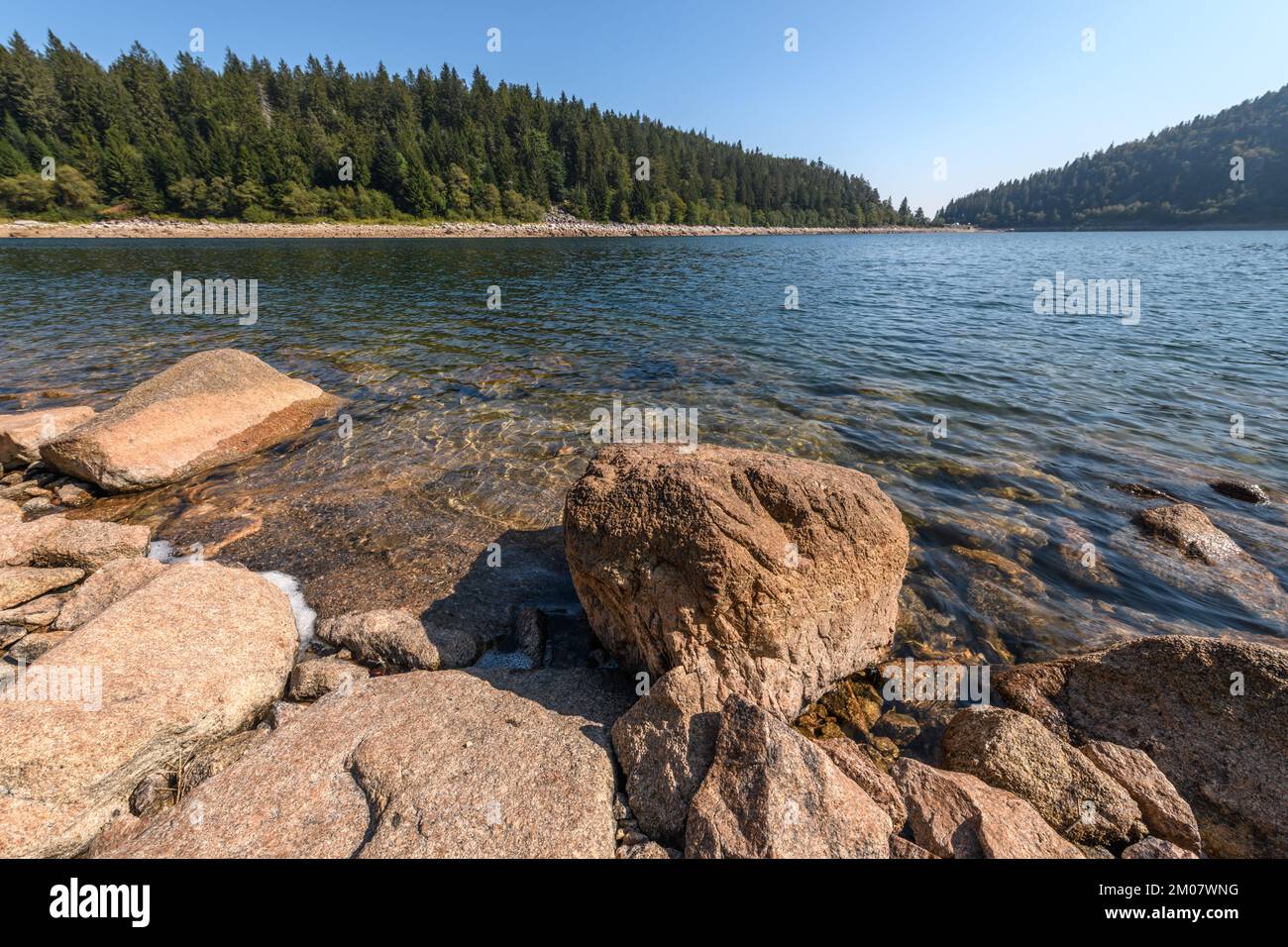 Mountain lake with a drop in the water level in times of drought. Lac ...