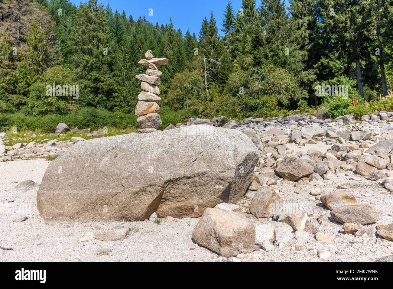 Pyramid of stones on a rock by a mountain lake. Vosges, Alsace, France ...