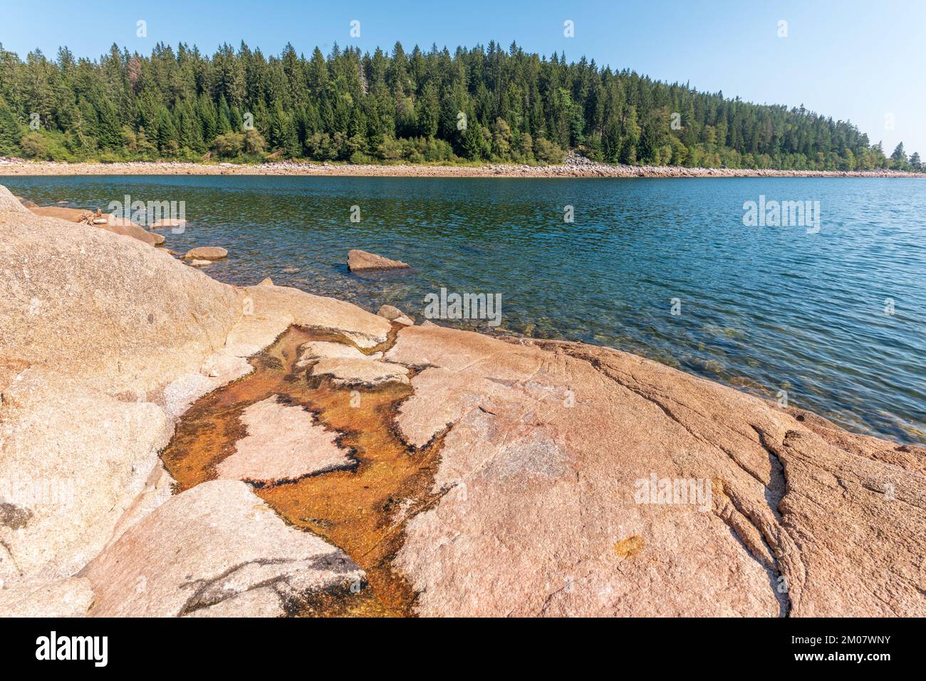 Mountain lake with a drop in the water level in times of drought. Lac ...