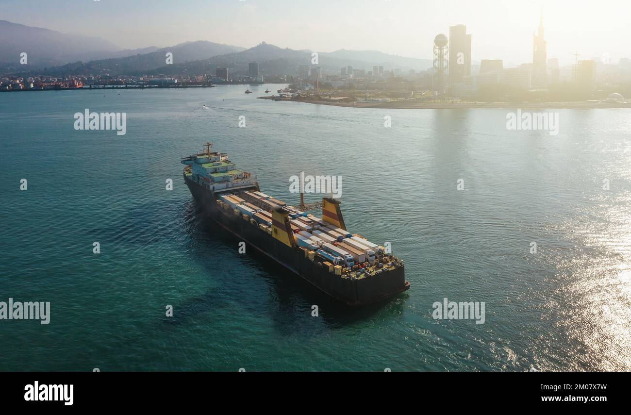 Freight cargo ship with trucks and containers in sea, aerial view from ...