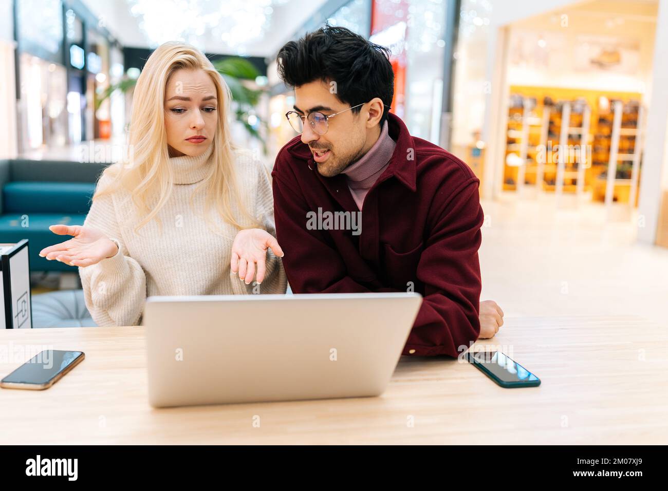 Portrait of attractive young couple using typing laptop computer ...