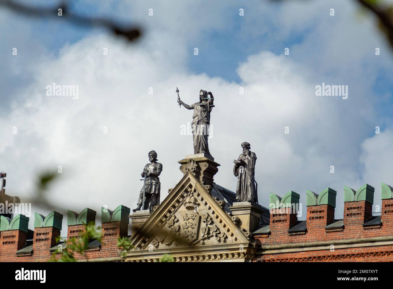A low-angle closeup of roof statues of Saint Canute's brick-built ...