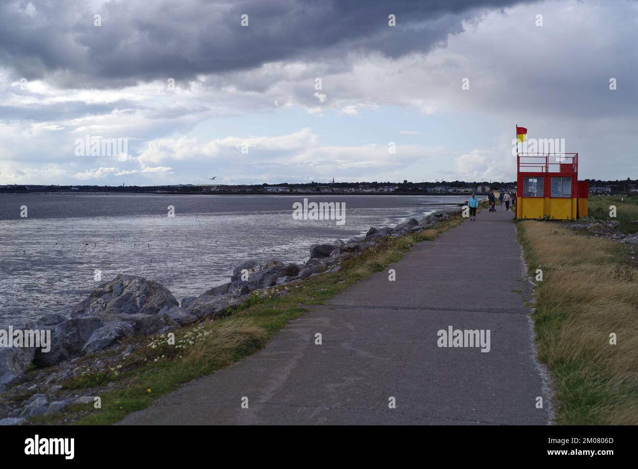 People walk along the seashore in Dollymount Strand situated on Bull ...