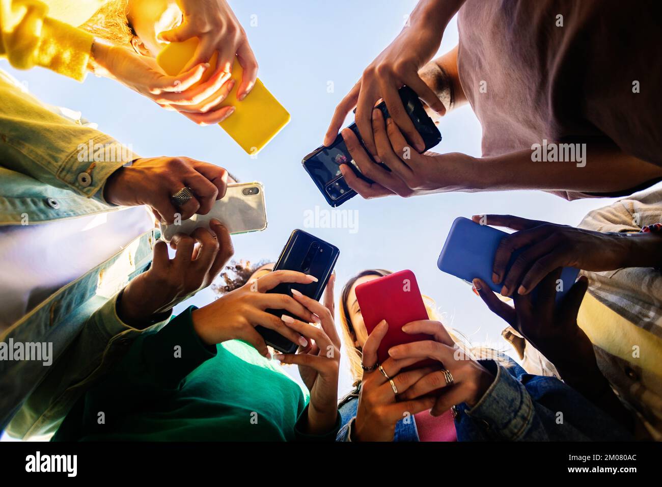 Group of people using phone outdoors hi-res stock photography and ...
