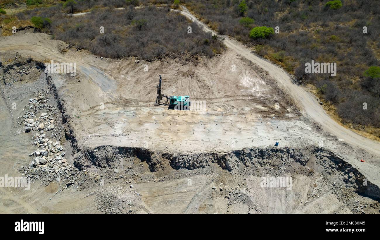 An aerial shot of a blue machine for placing explosives in a cement ...