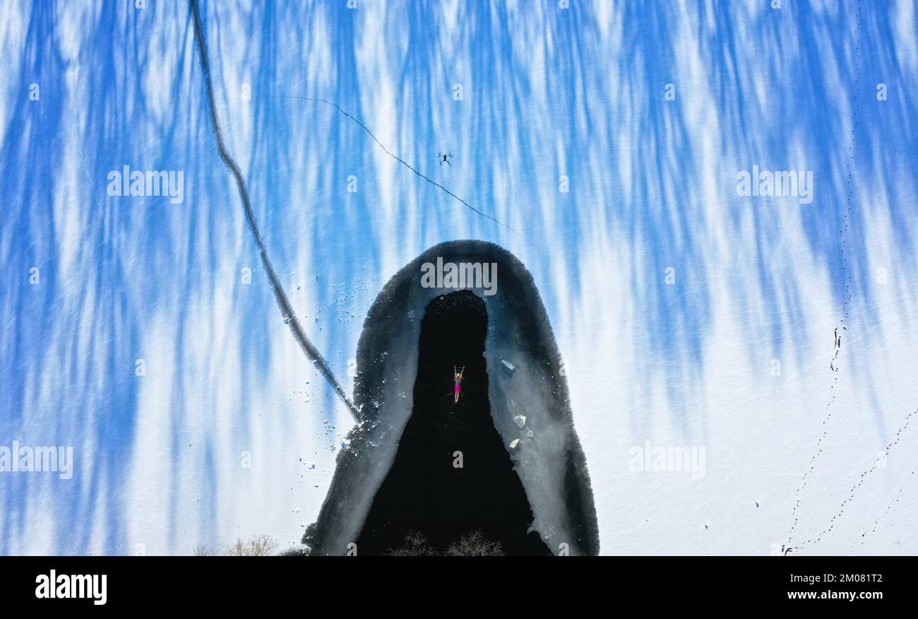 Aerial photo shows winter swimming enthusiasts swimming in the ice lake ...