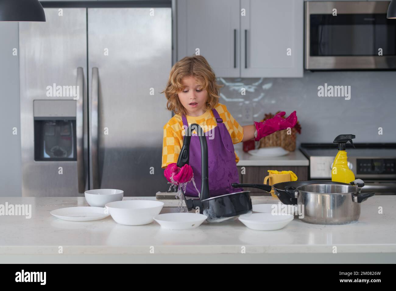 Cleaning at home. Kid wiping dishes in kitchen. Child cleaning and ...