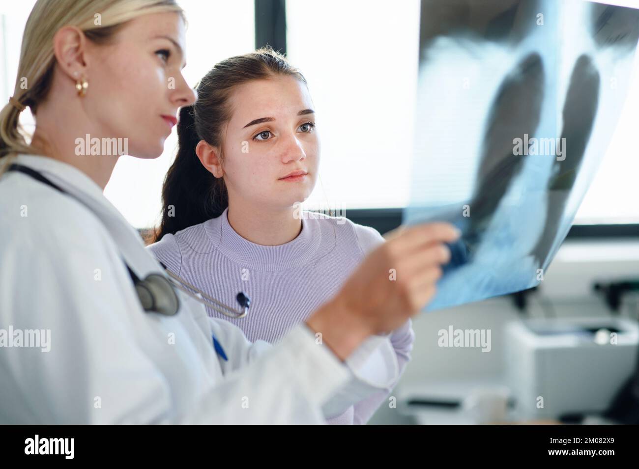 Young woman doctor showing x-ray image of lungs to her patient Stock ...