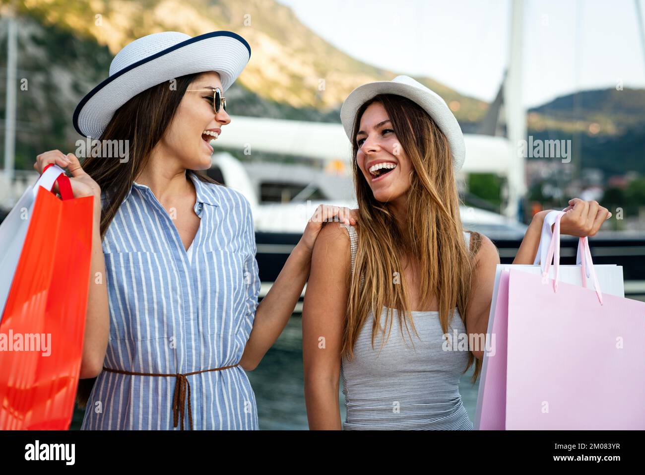 Two beautiful young women enjoying shopping and travel in the city ...