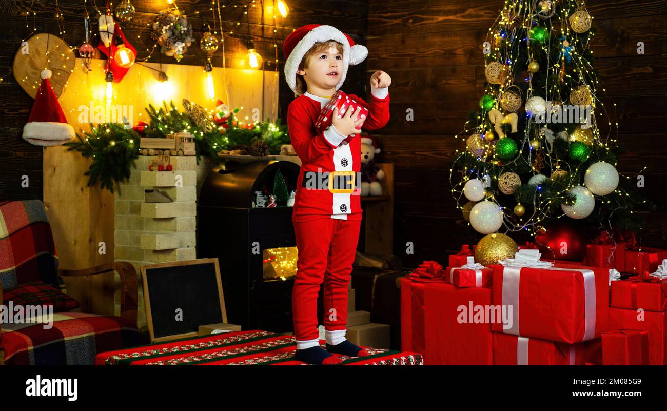 Child with decorating Christmas tree and having fun. New Year surprise ...