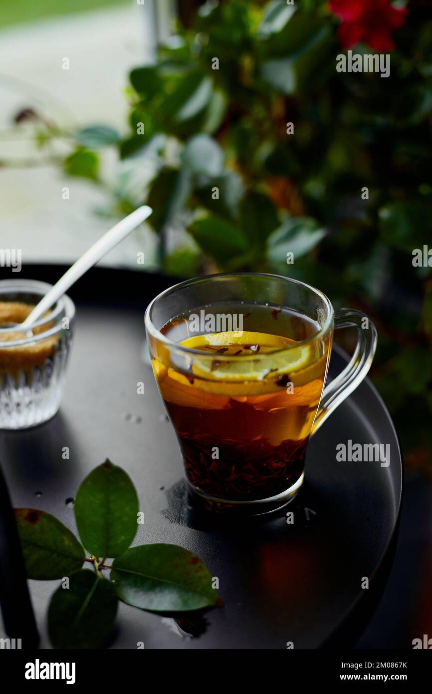 Glass cup of hot black tea lemon on dark background with steam near ...