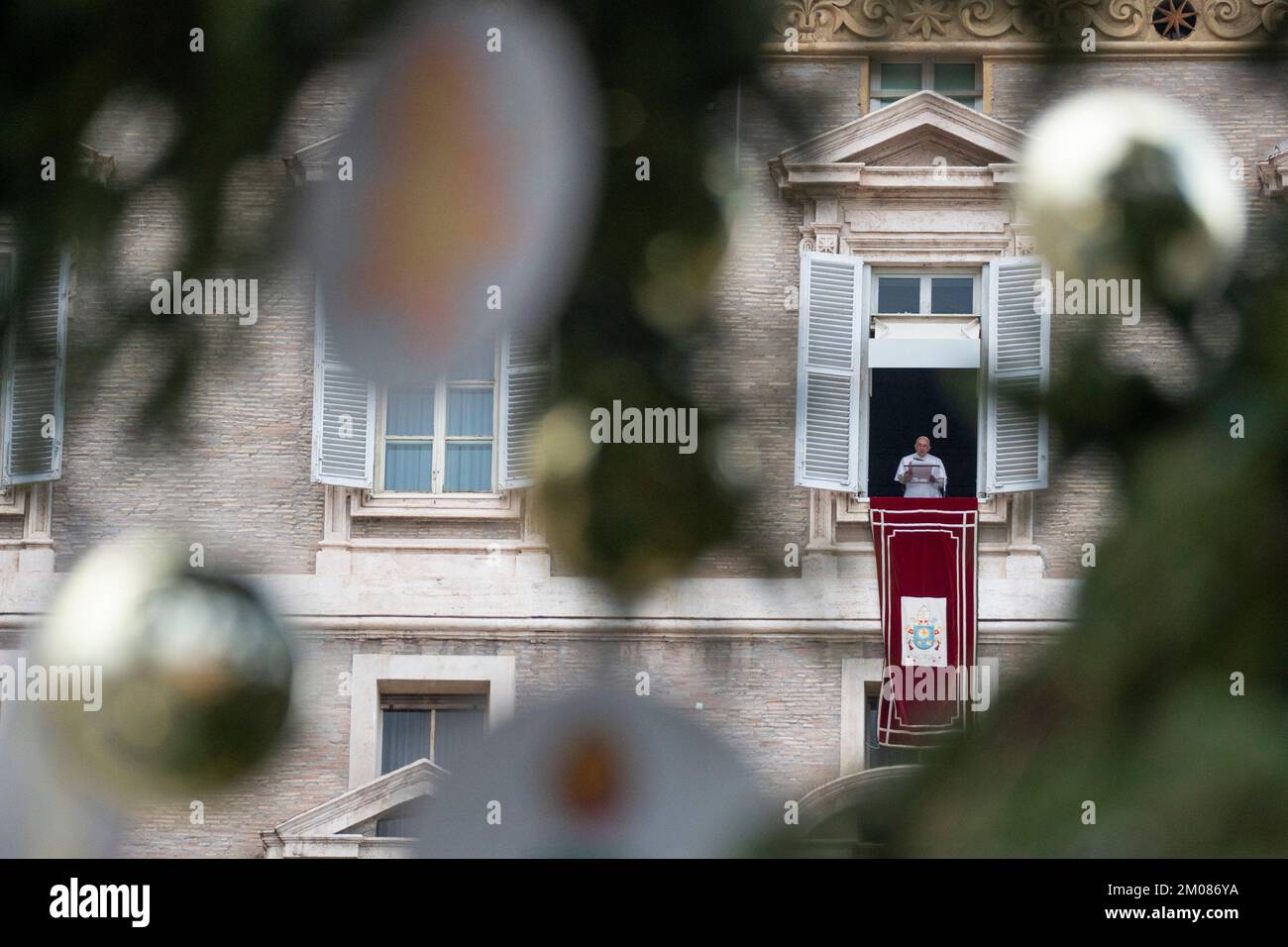 Pope Francis framed by the branches and decorations of a Christmas tree ...