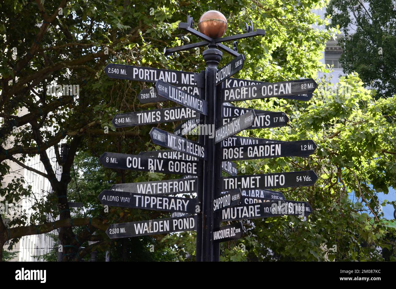closeup of a directional sign with a lot of locations in Portland on a ...