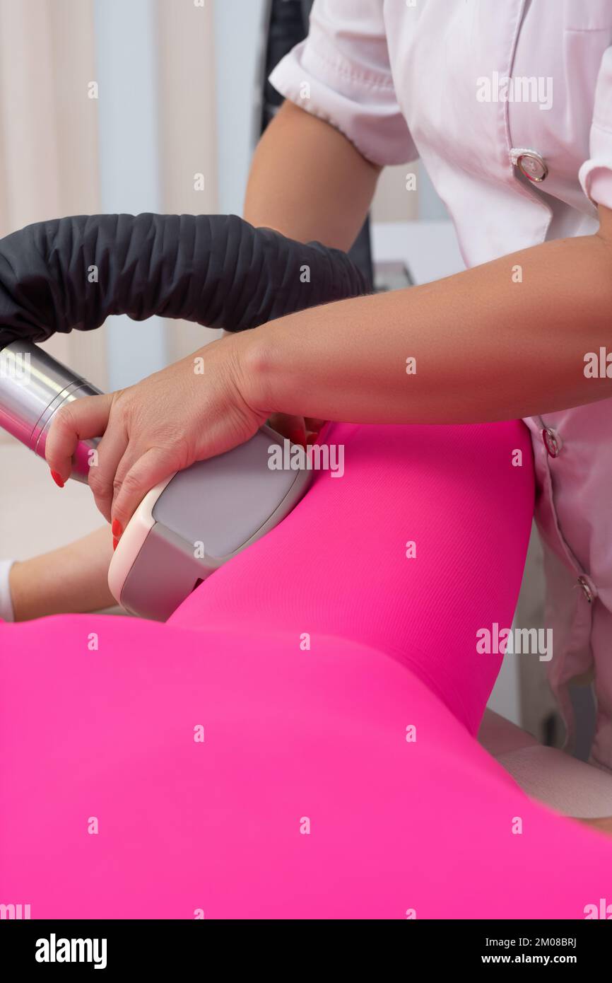 Crop Masseuse Doing Vacuum Massage To Female Leg In Rose Costume Stock
