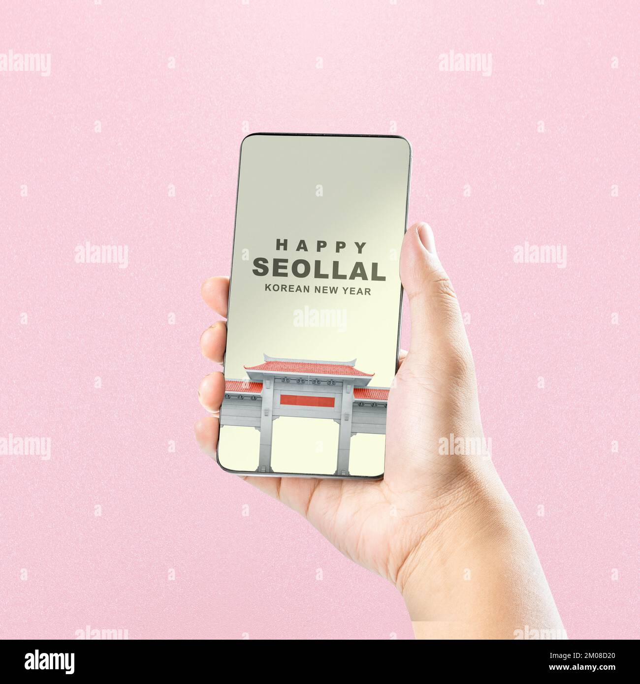 Hand holding mobile phone with greetings of Happy Seollal on the screen ...