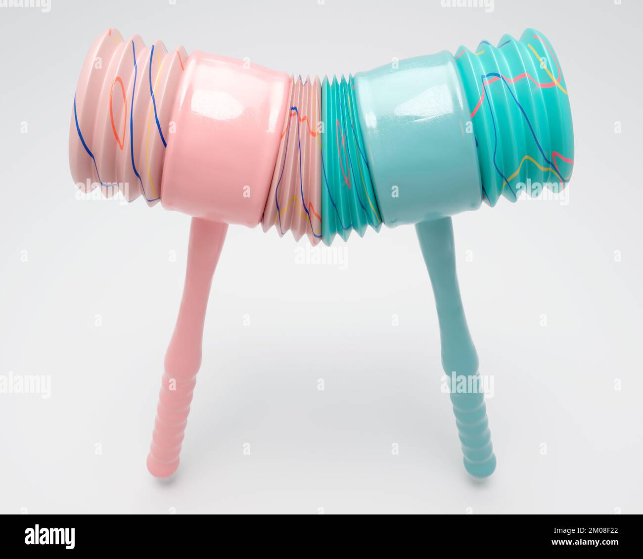 Two opposing plastic childrens squeaking hammers striking each other on ...