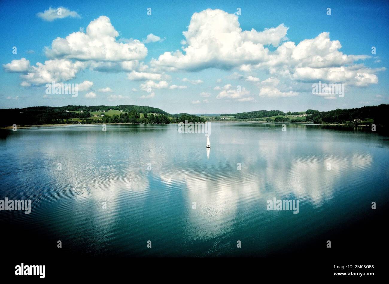 An aerial view of boat floating in lake Mattsee surrounded by dense ...