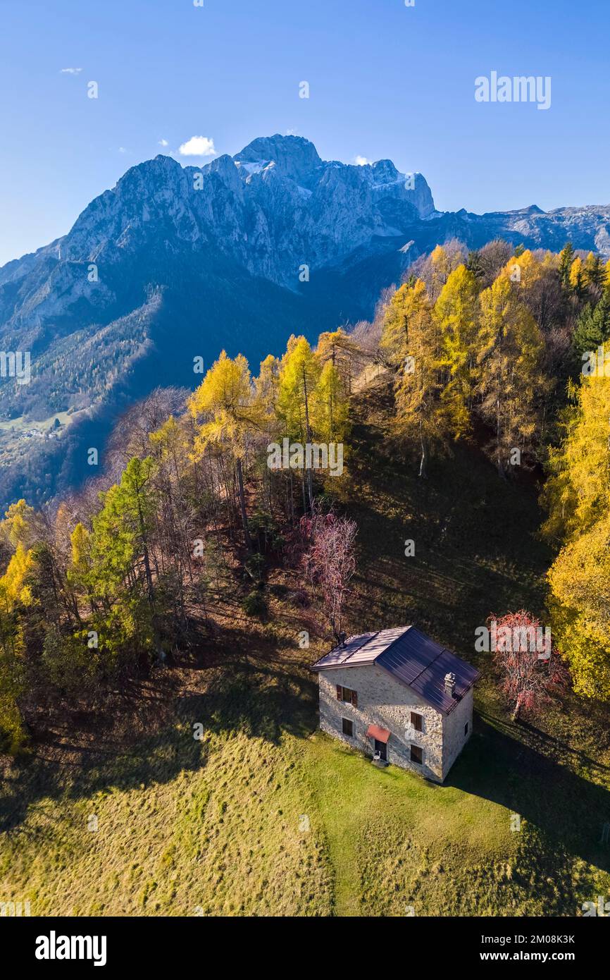 Aerial view of a small hut in Azzone in front of the Presolana massif ...
