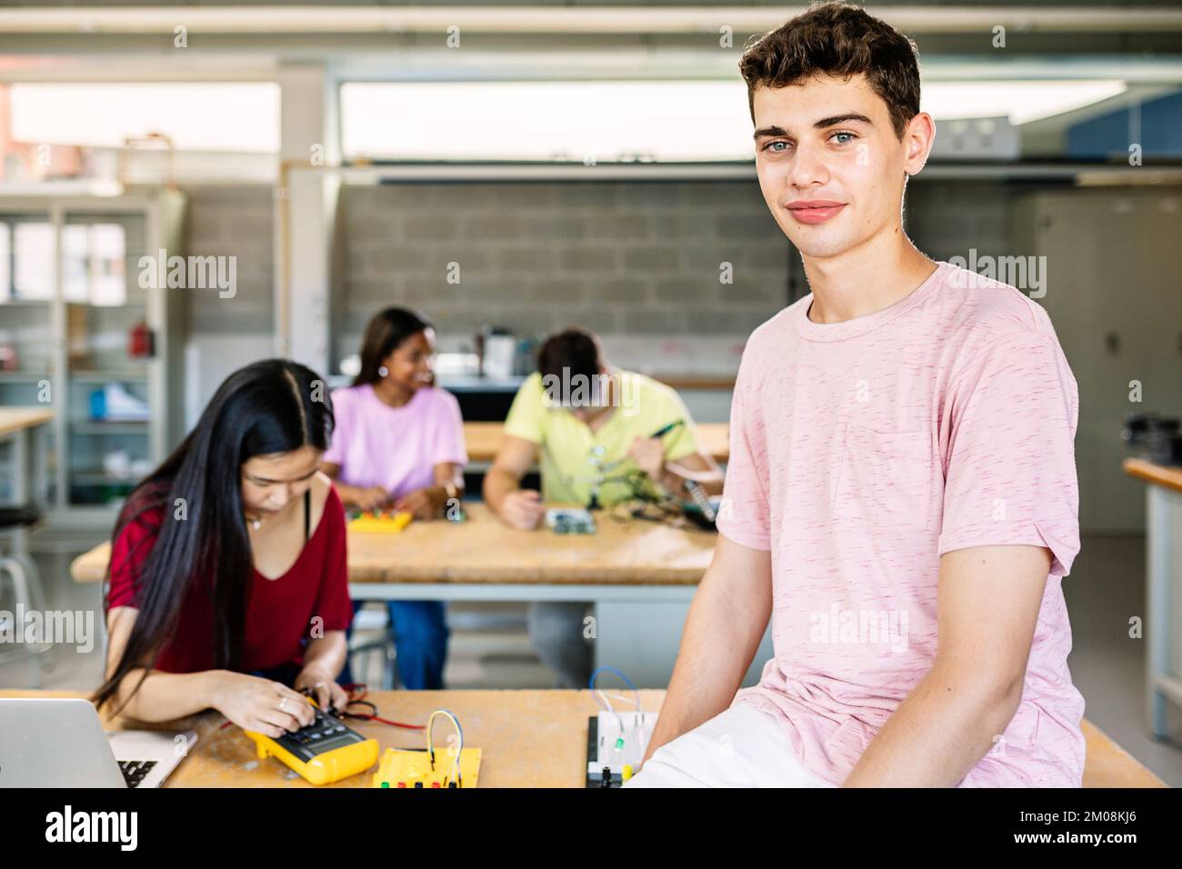 Young guy student man smiling at camera standing at electronic ...