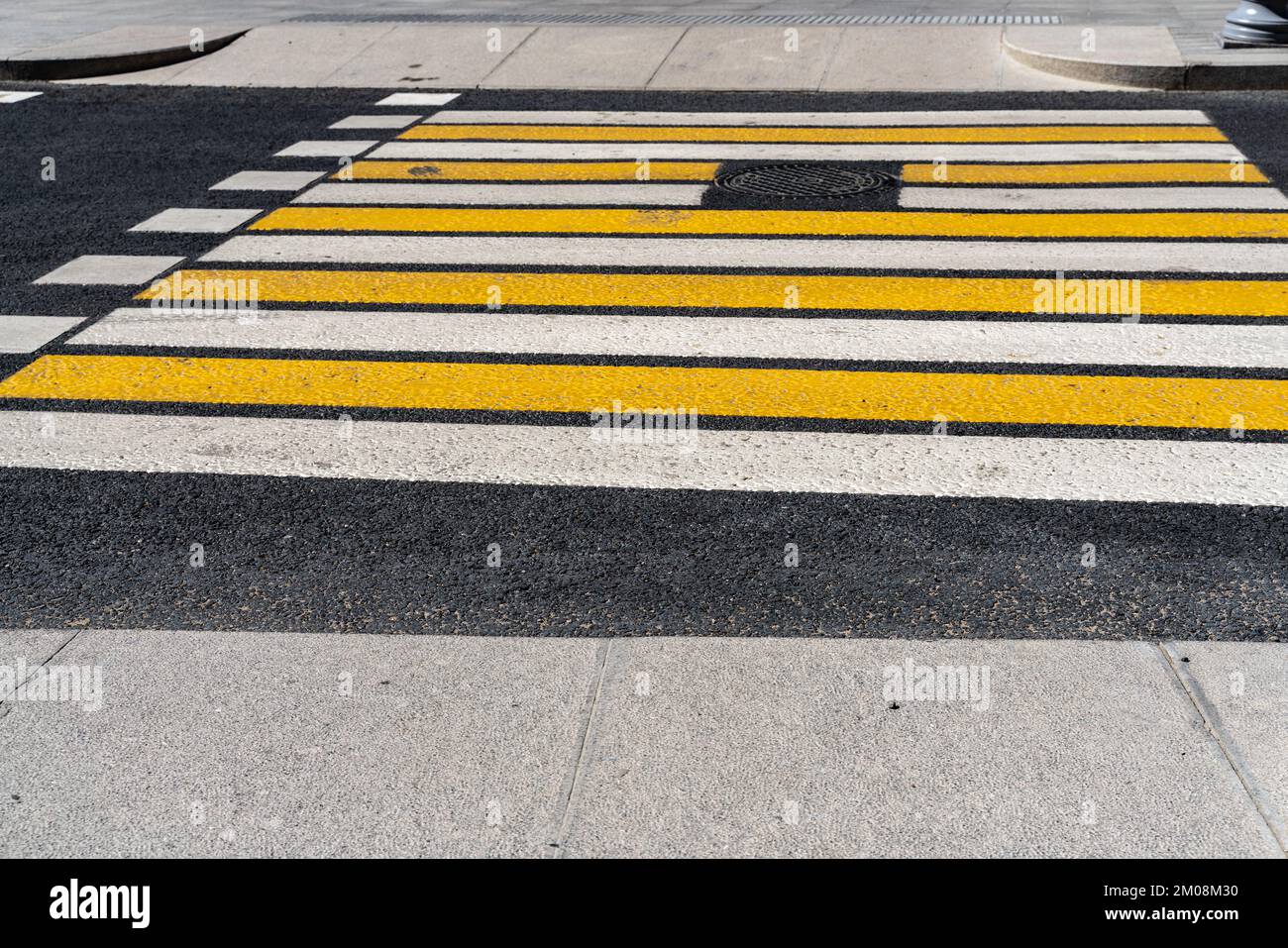 Striped yellow and white pedestrian zebra crossing on gray asphalt ...