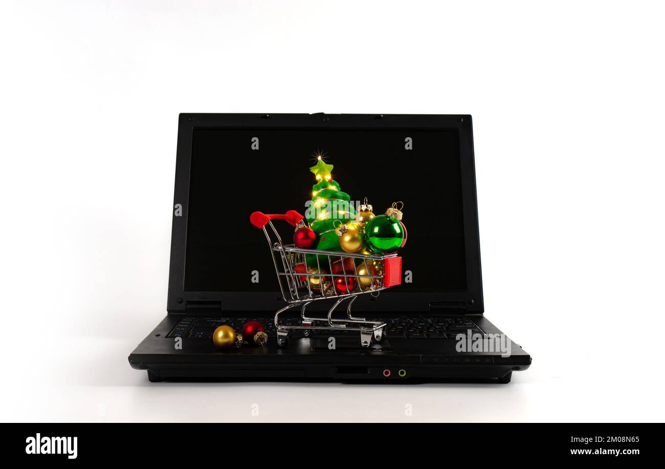 Shopping trolley with christmas balls and tree with garlands on the ...