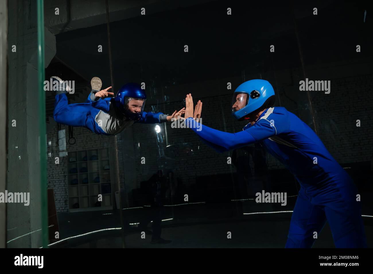 A man teaches a boy to fly in a wind tunnel. Lack of gravity Stock ...