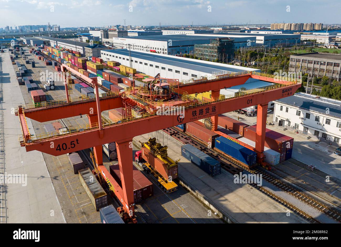 Workers operate heavy lifting equipment to lift containers at the Haian ...