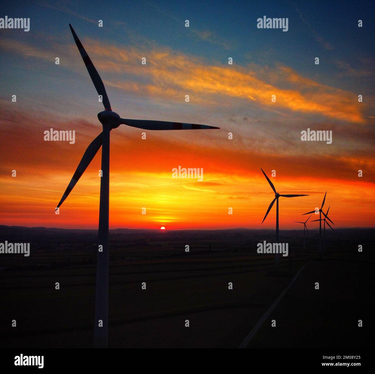 A breathtaking view of wind turbines spinning in the field on dark ...