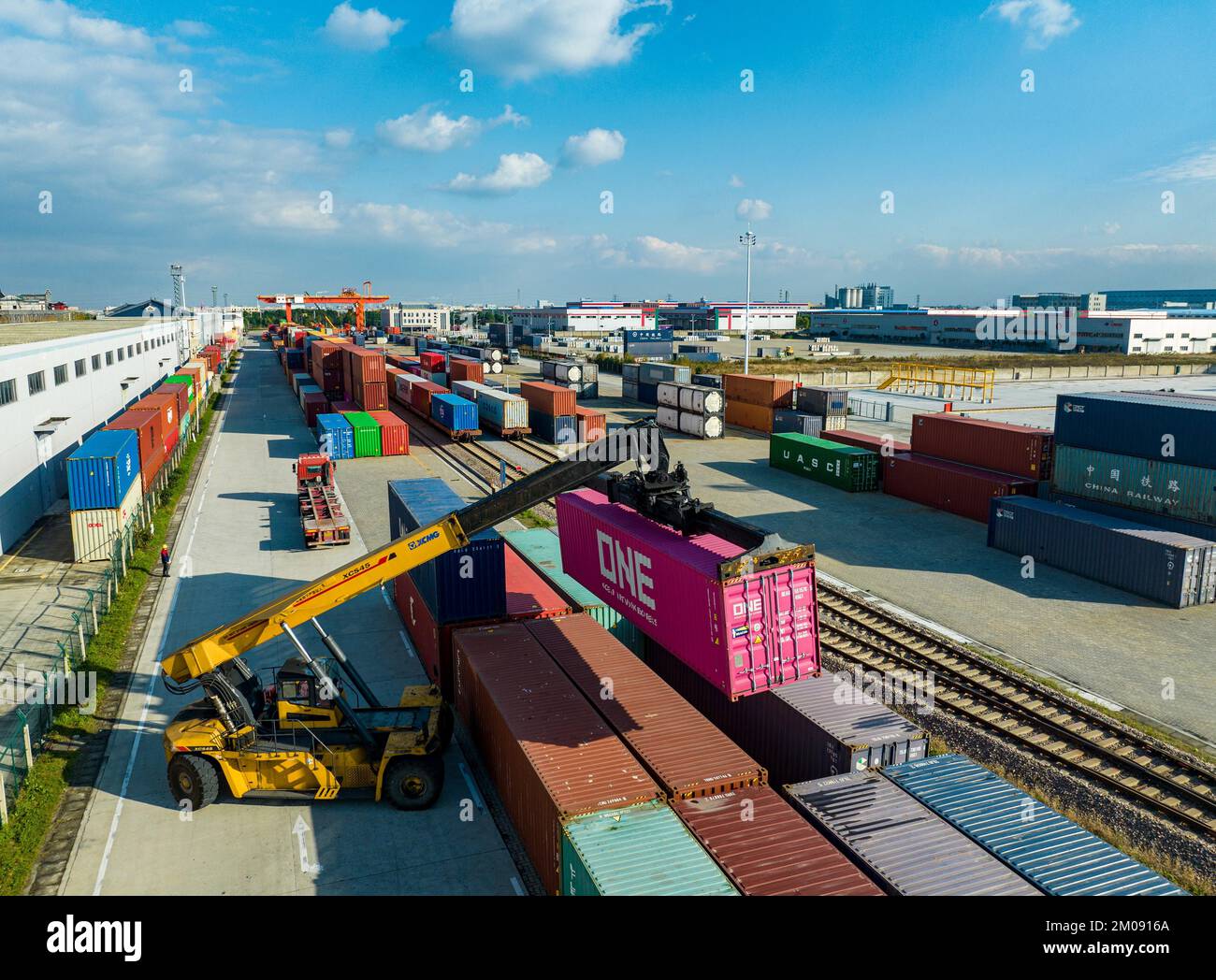 Workers operate heavy lifting equipment to lift containers at the Haian ...