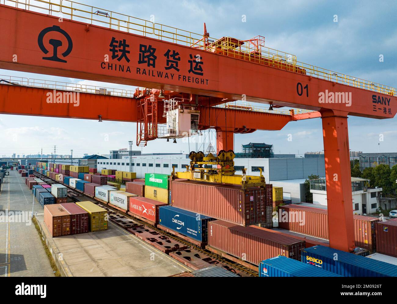 Workers operate heavy lifting equipment to lift containers at the Haian ...