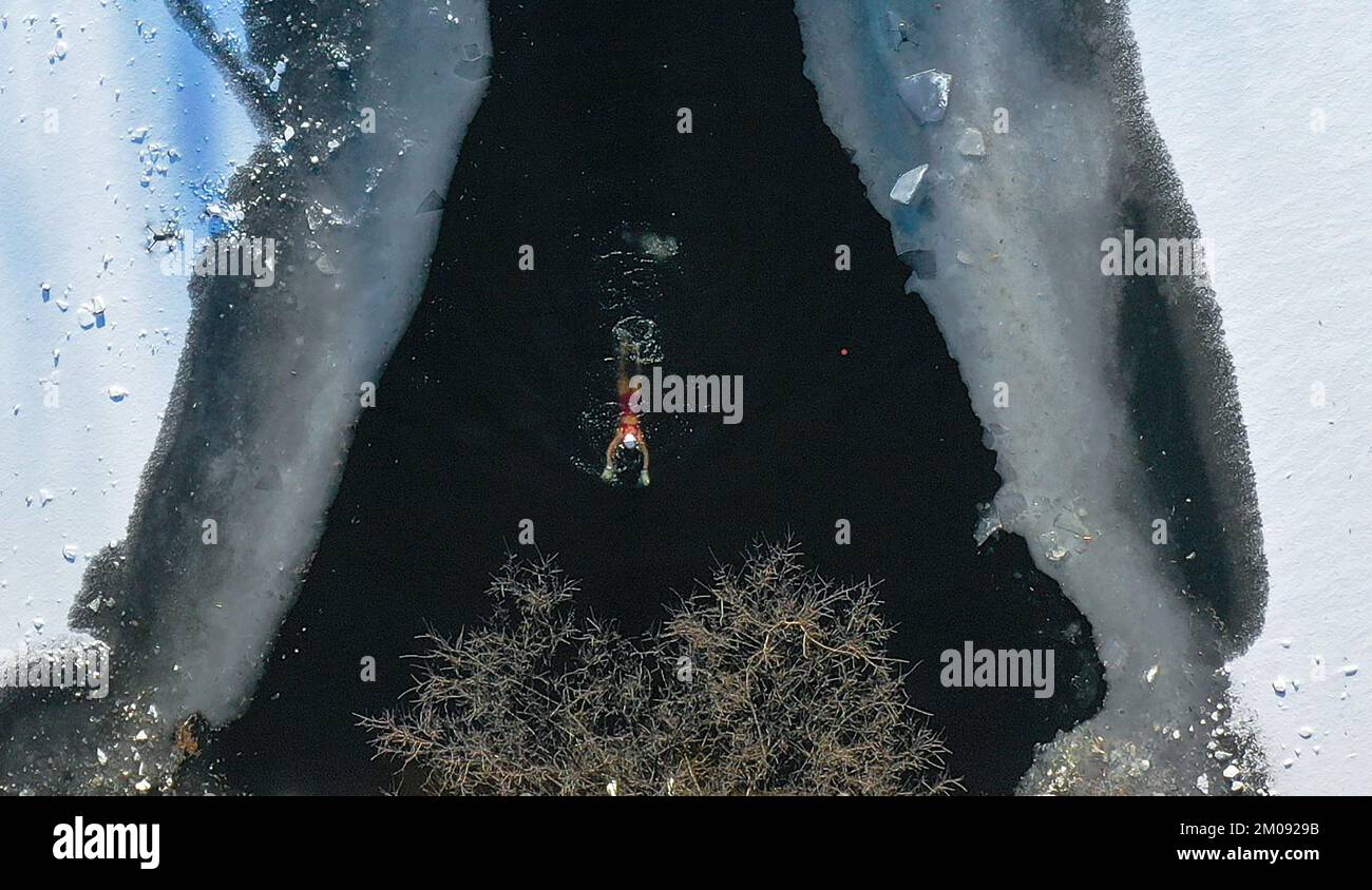 Aerial photo shows winter swimming enthusiasts swimming in the ice lake ...