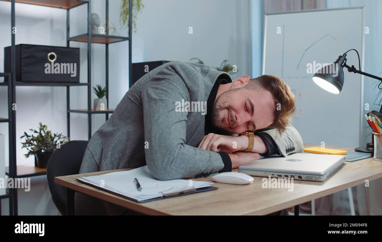 Bored sleepy business man worker working on laptop computer, yawning ...
