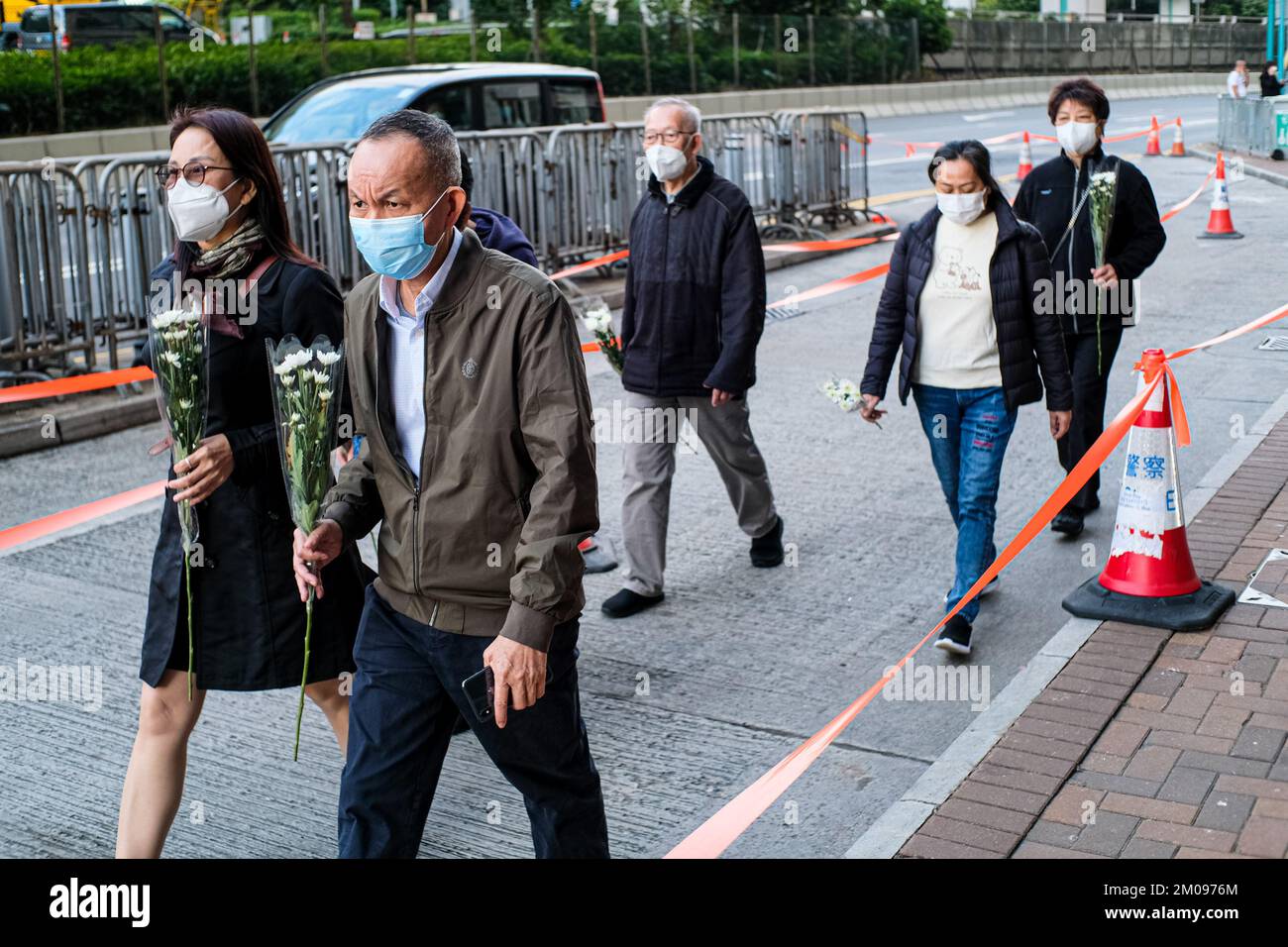 Hong Kong, China. 5th Dec, 2022. Mourners bring flowers to pay respect ...