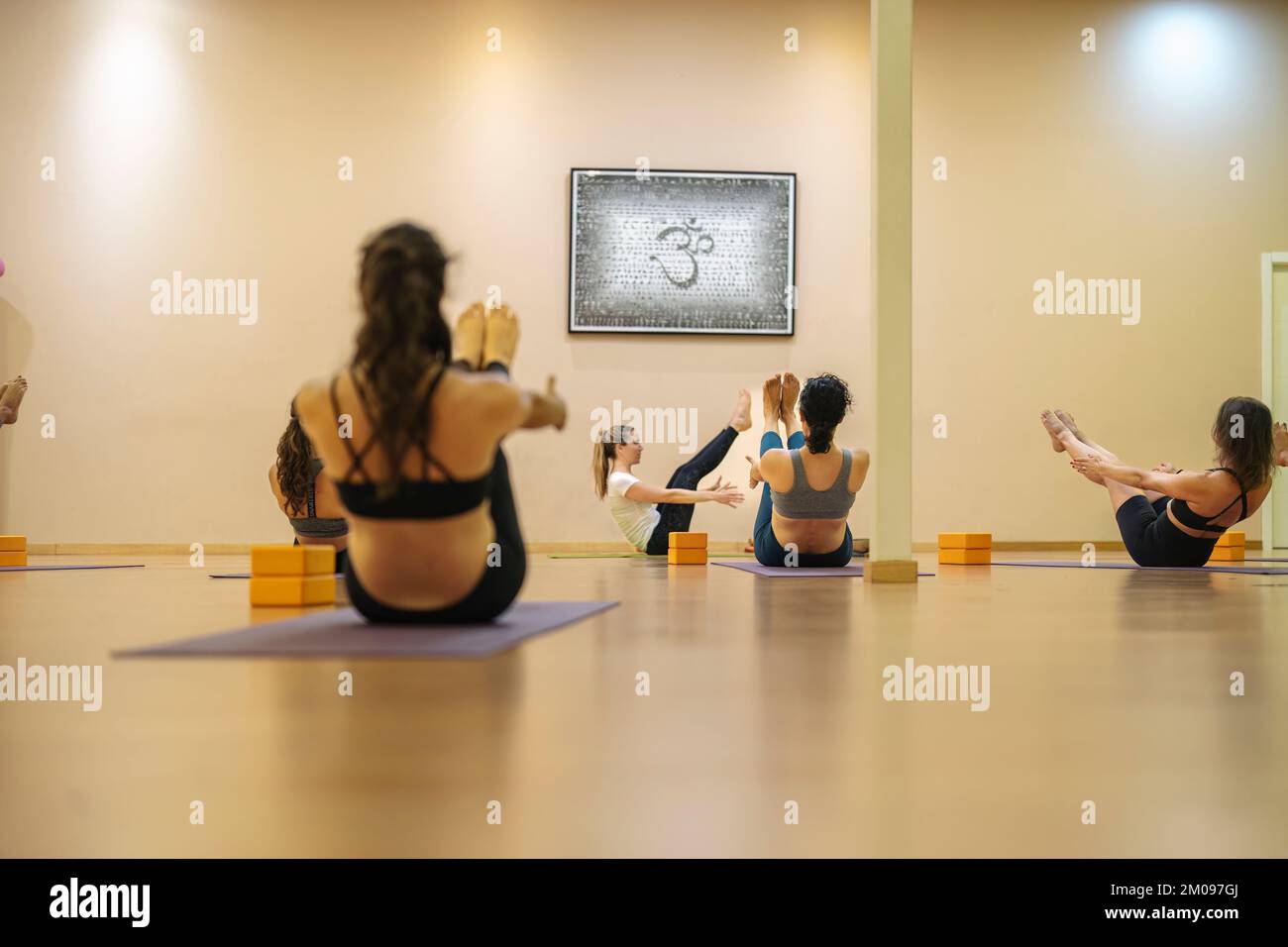 yoga instructor explaining navasana posture in yoga class Stock Photo - Alamy