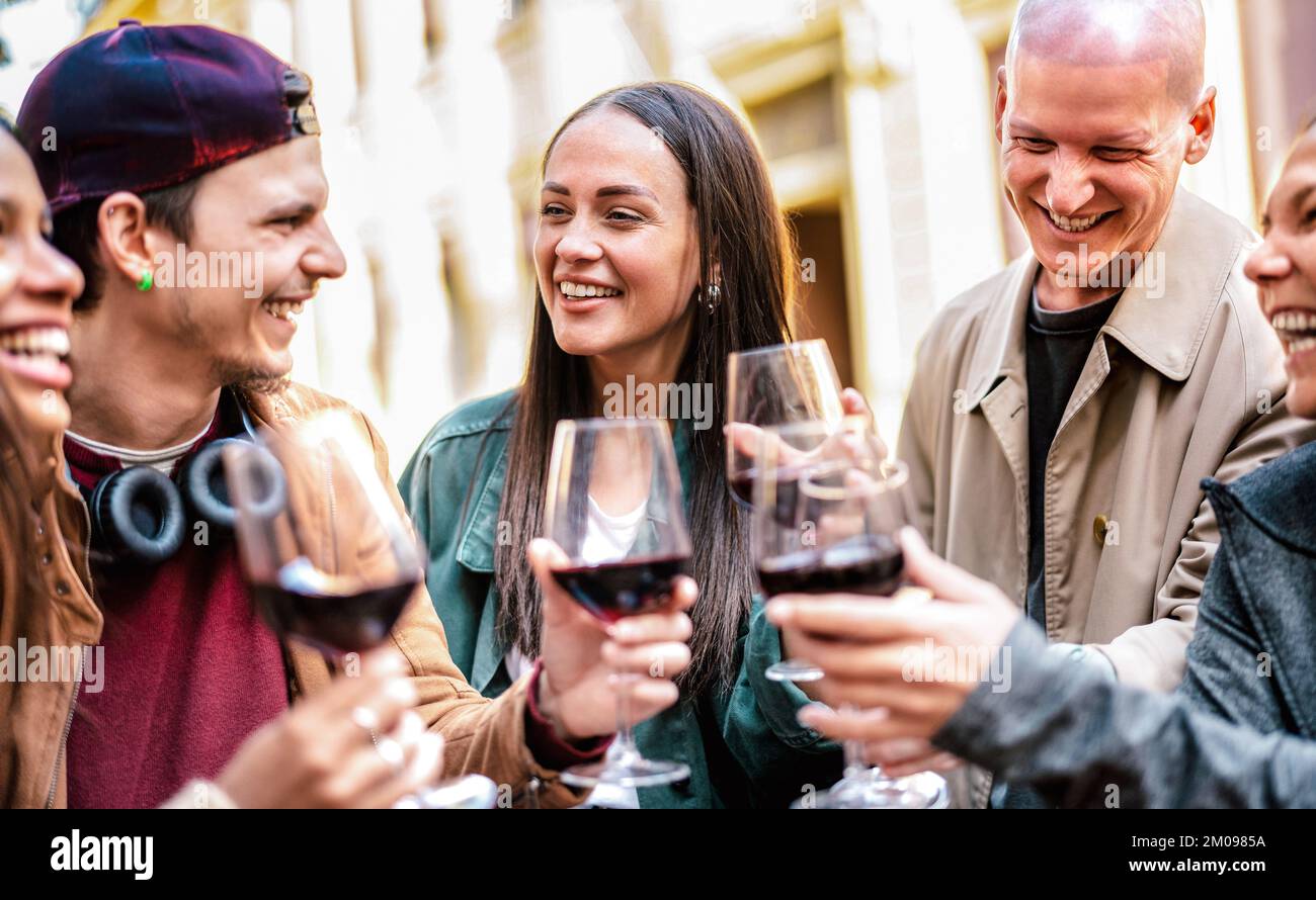 Young people having fun drinking red wine out side at city winery bar ...