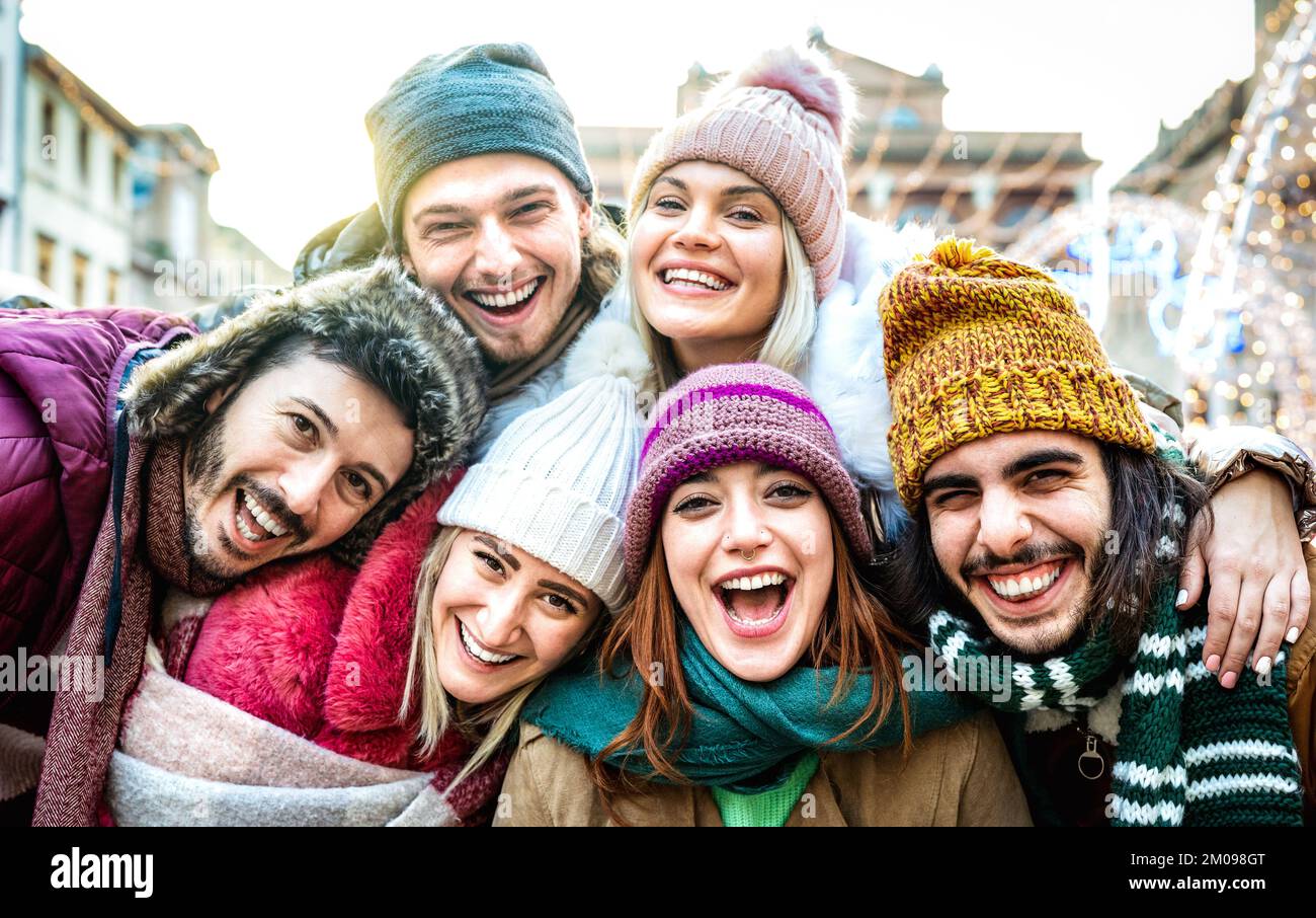 Trendy friends guys and girls taking funny selfie on warm fashion ...