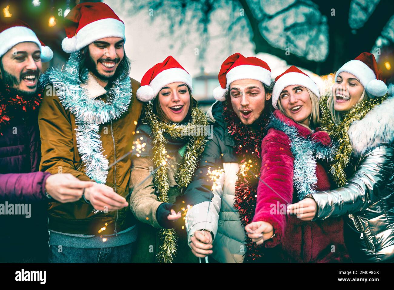Young people group cheering with sparklers at Christmas time - Cold ...