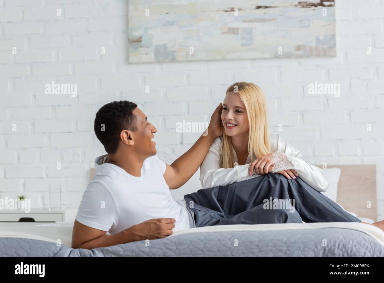 happy african american man touching hair of young blonde girlfriend on ...