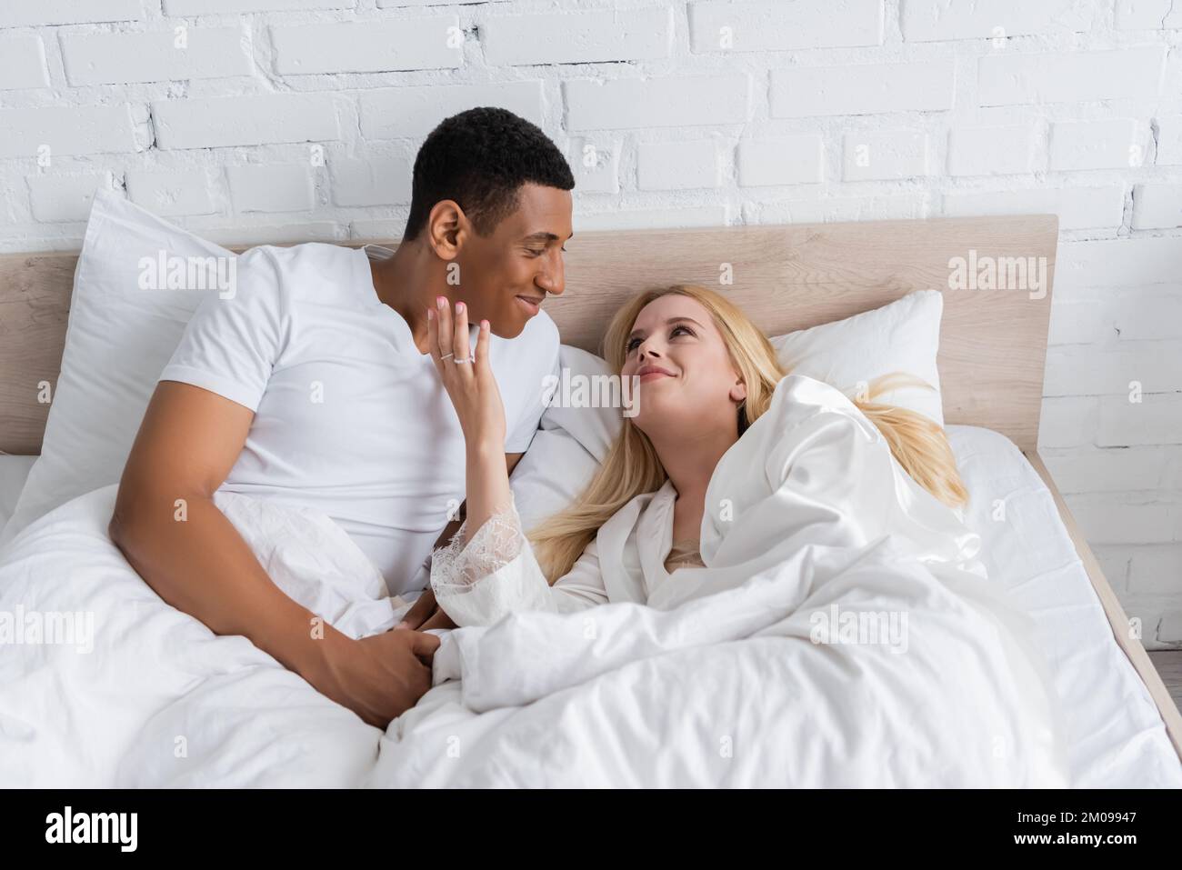 smiling african american man looking at young and happy girlfriend ...
