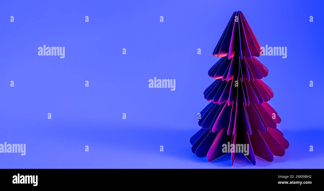 Decorative paper Christmas tree on blue background with trendy neon ...