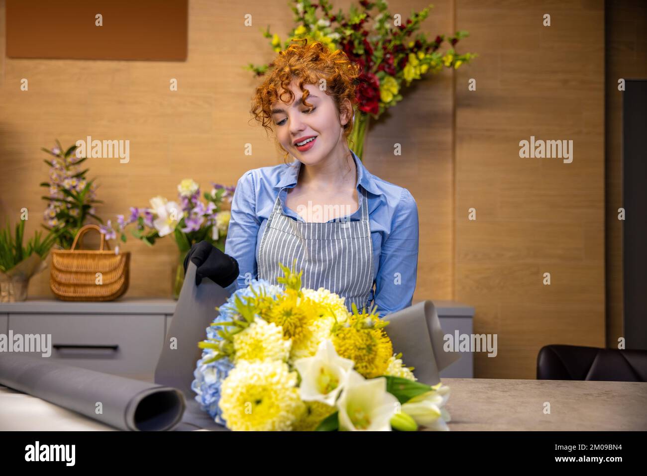Cute ginger young woman standing at the table in a flower shop Stock ...