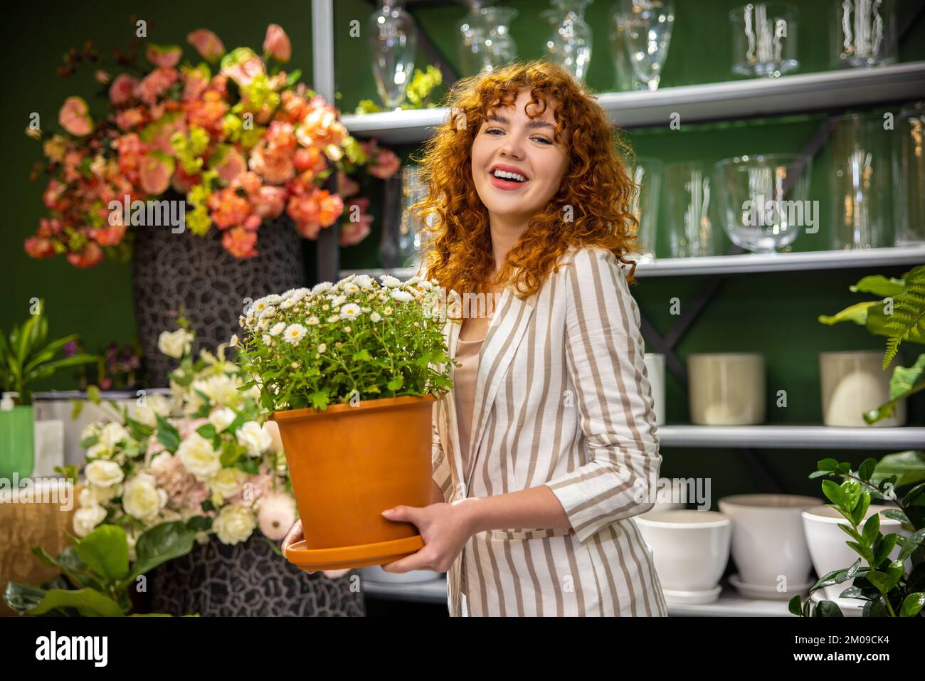Curly-haired ginger florist holding flower pots Stock Photo - Alamy