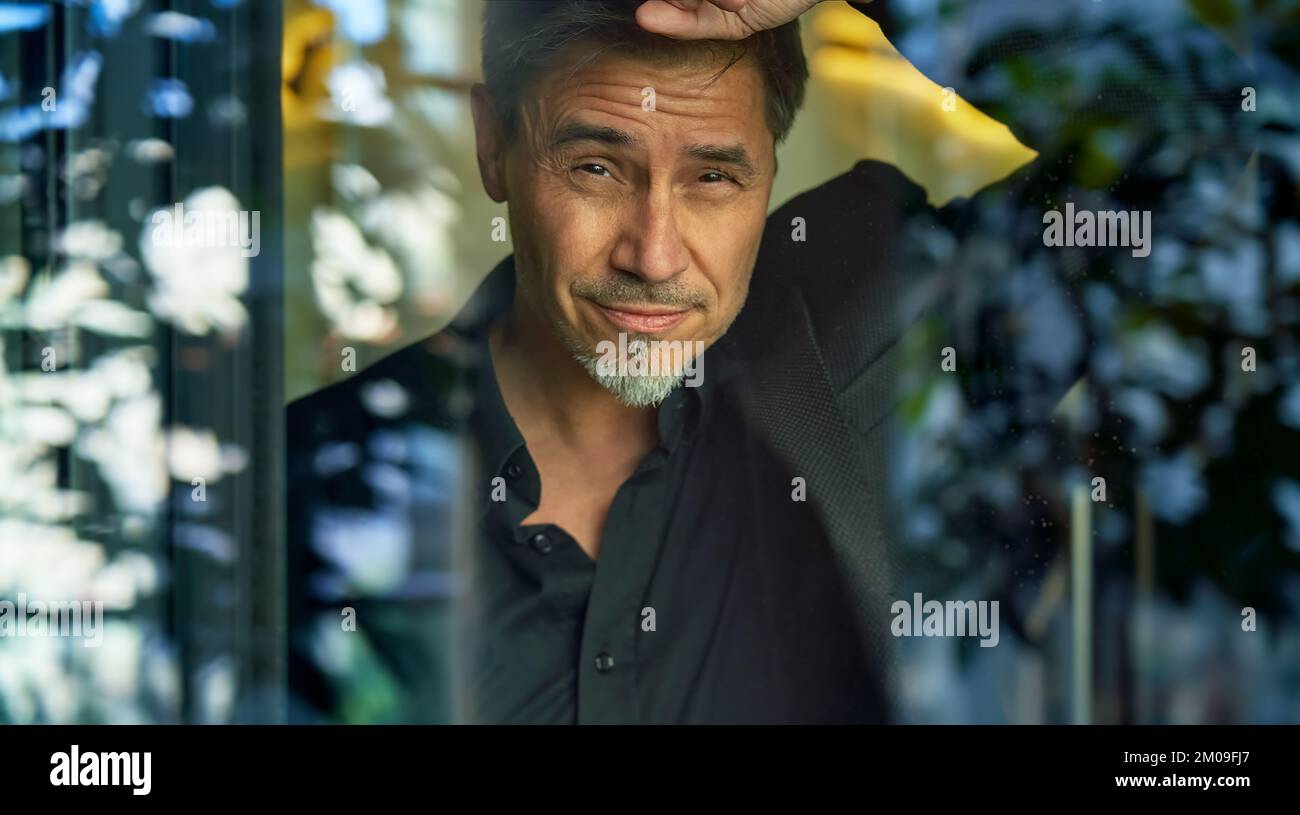 Business portrait - businessman looking through window in office ...