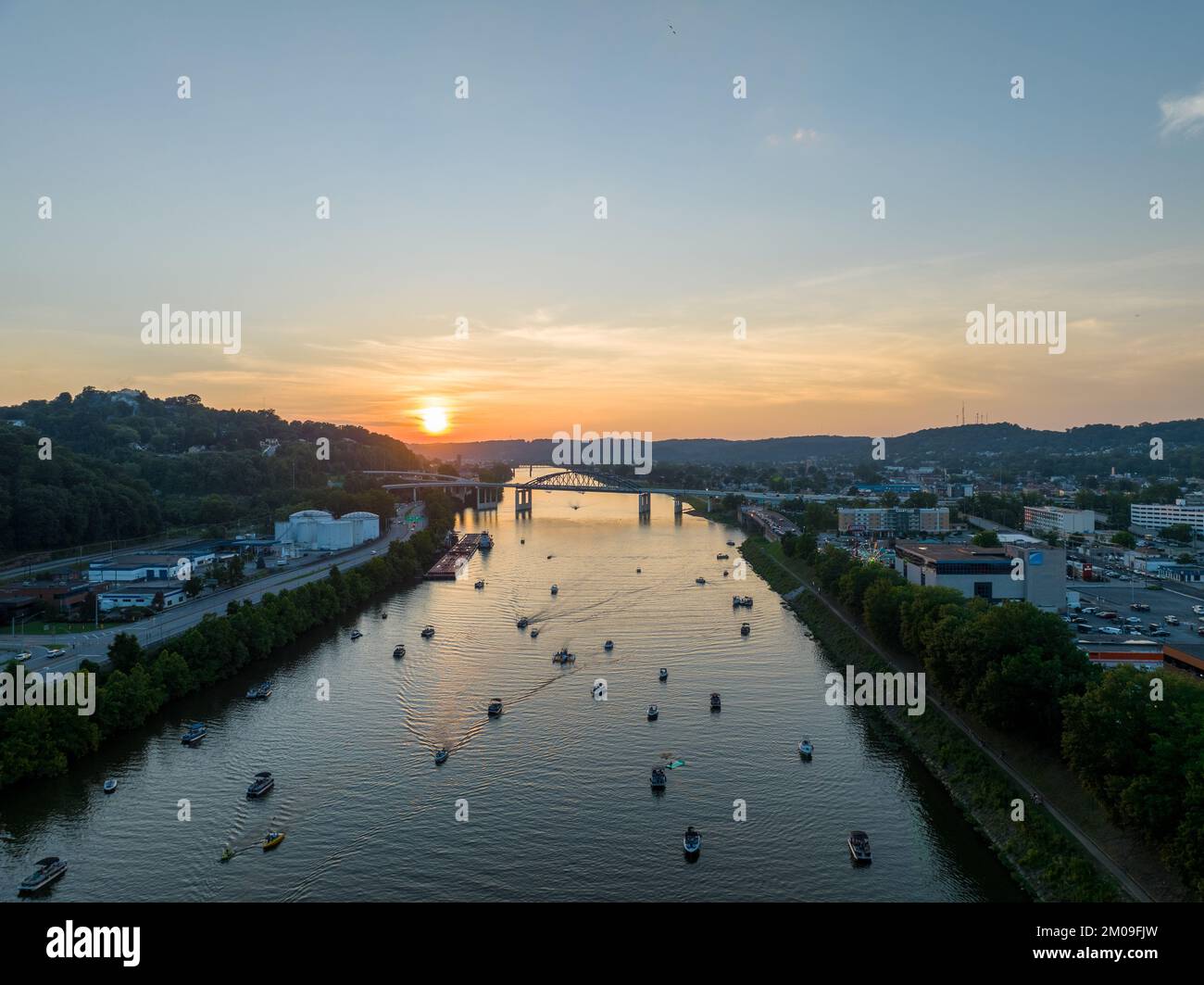 An aerial view of the sun setting behind boaters on the river Stock ...